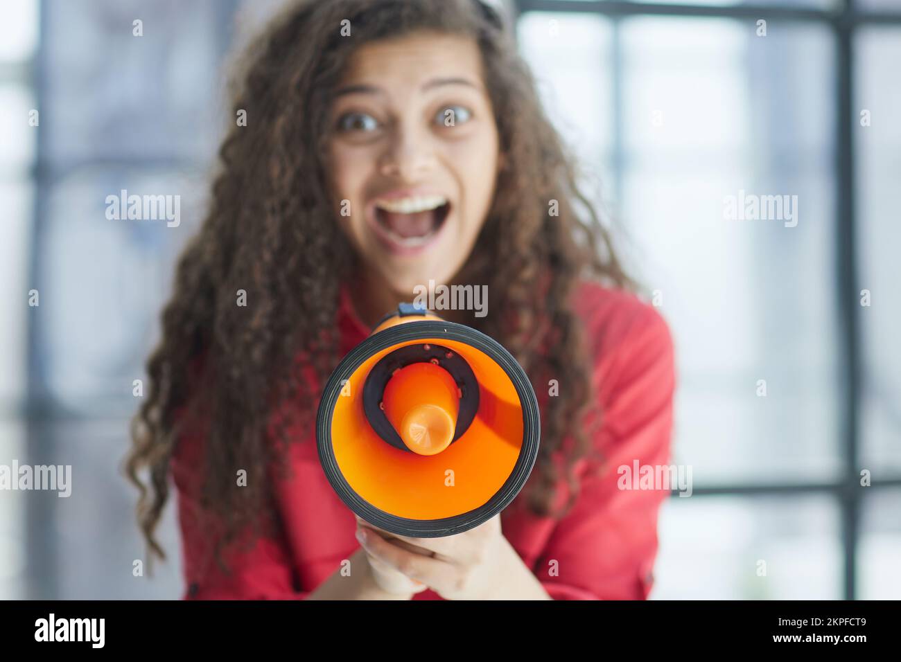 Beautiful girl shouting into a megaphone in a modern office Stock Photo ...