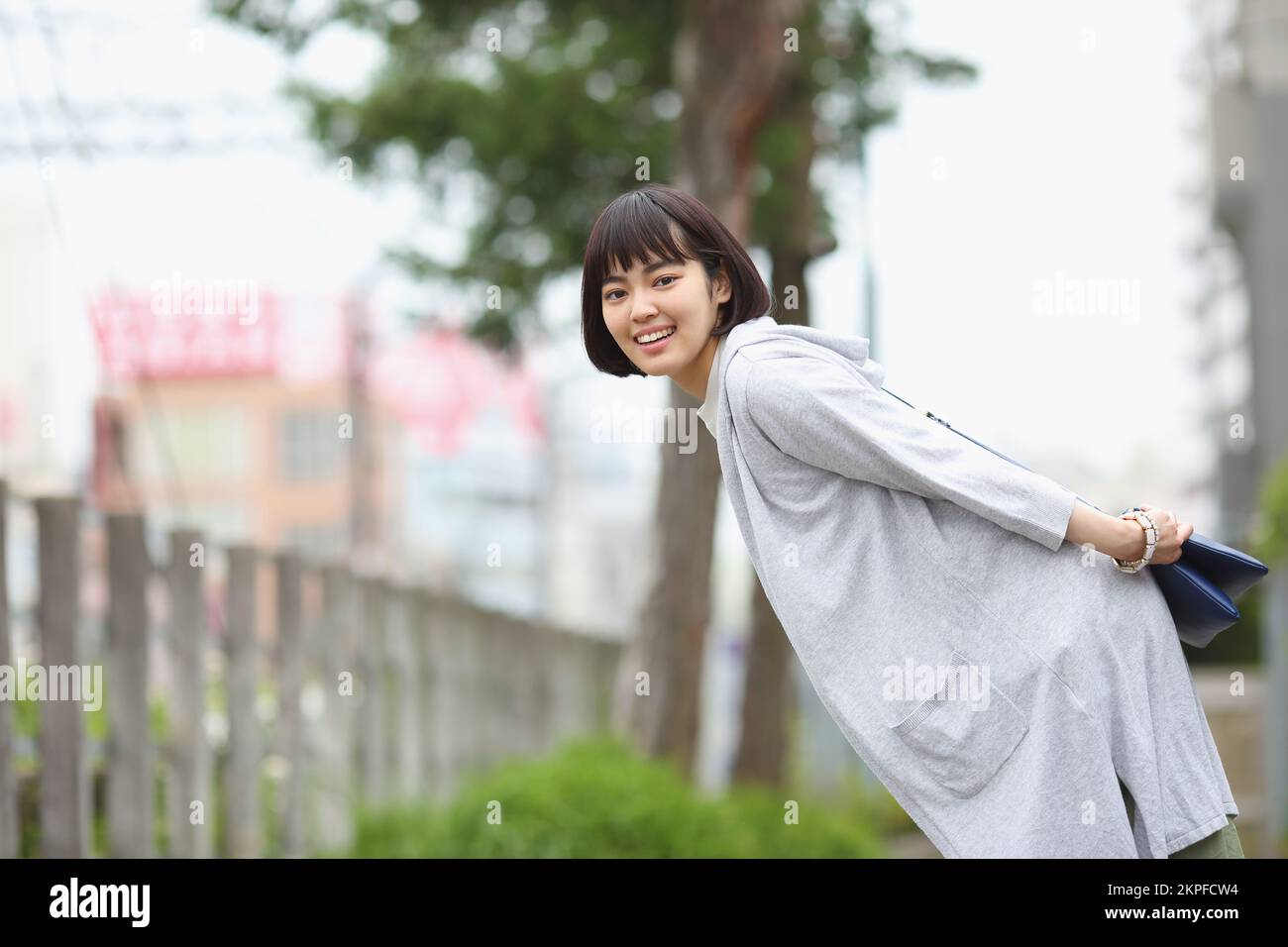Young Japanese woman walking along the railway fence Stock Photo - Alamy