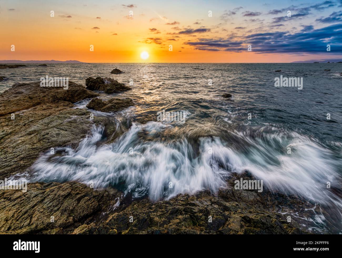 An Ocean Wave Is Breaking Against A Colorful Sunset Sky In High ...
