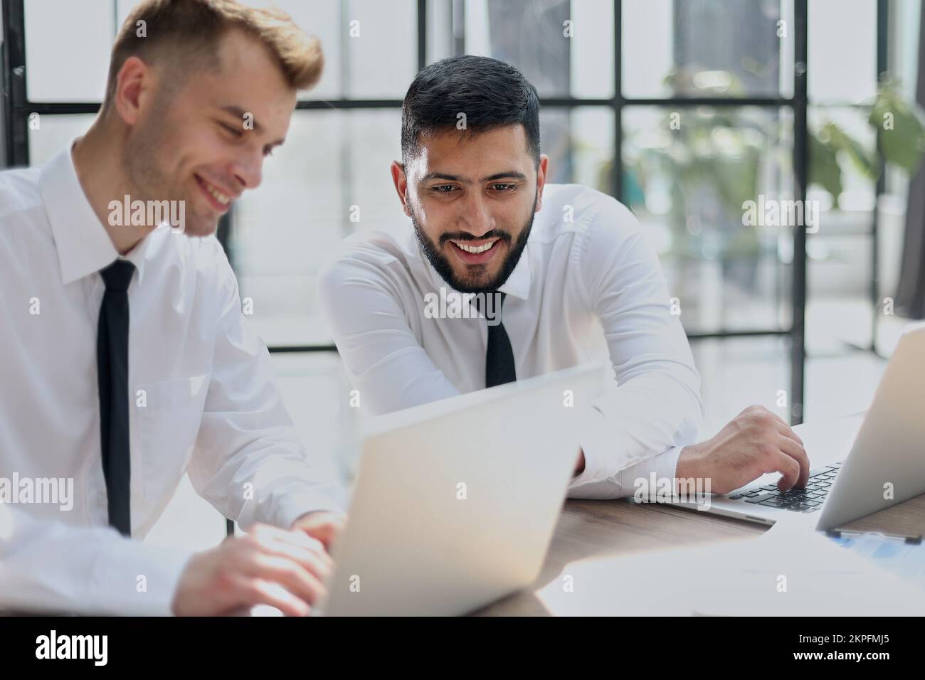 Two happy men working together on a new business project Stock Photo ...