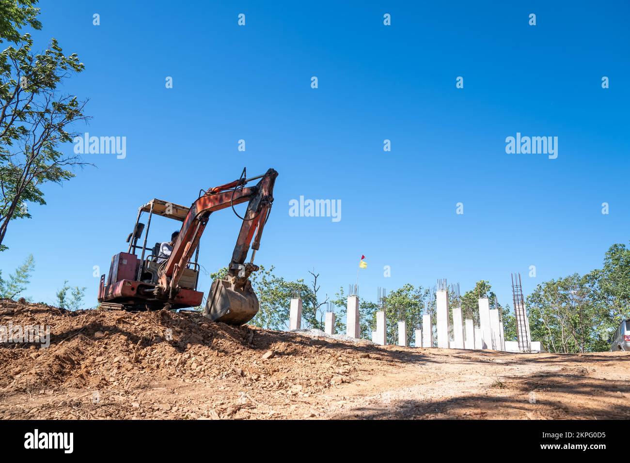 Hydraulic excavator is digging soil at a construction site, surrounded ...
