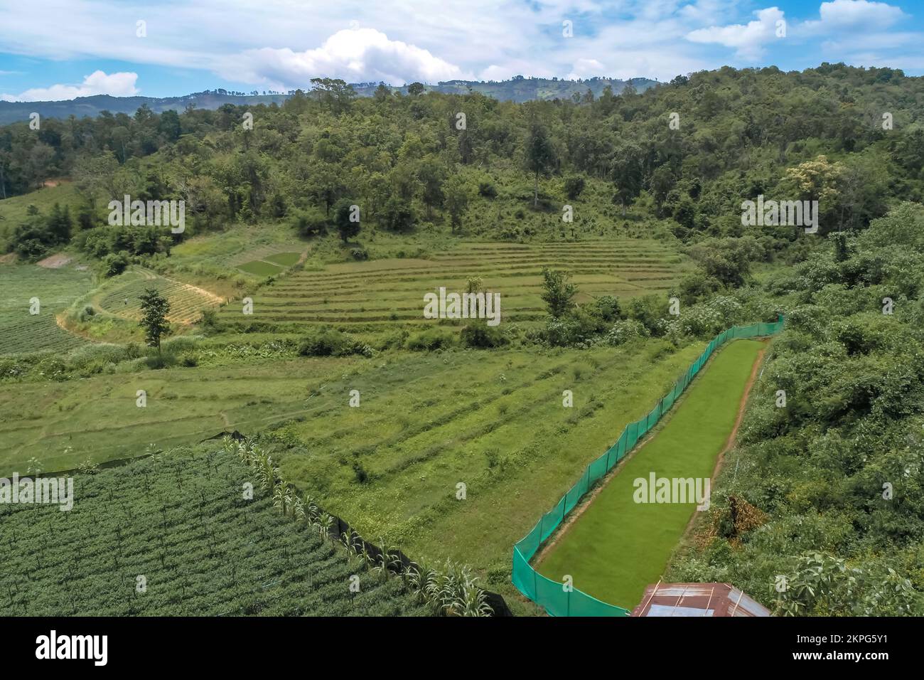 Aerial view of terraced agriculture field among greenery mountains with ...