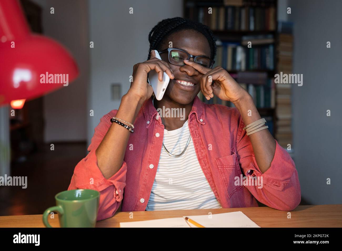 Laughing African student guy talking on smartphone, being distracted by ...