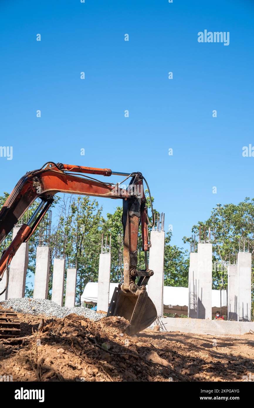 Hydraulic excavator is digging soil at a construction site, surrounded ...
