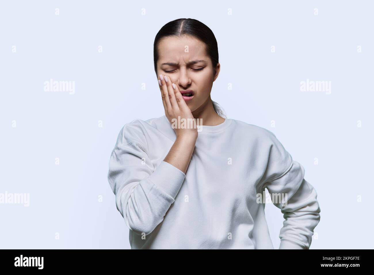 Teenage girl having toothache, on white studio background Stock Photo ...