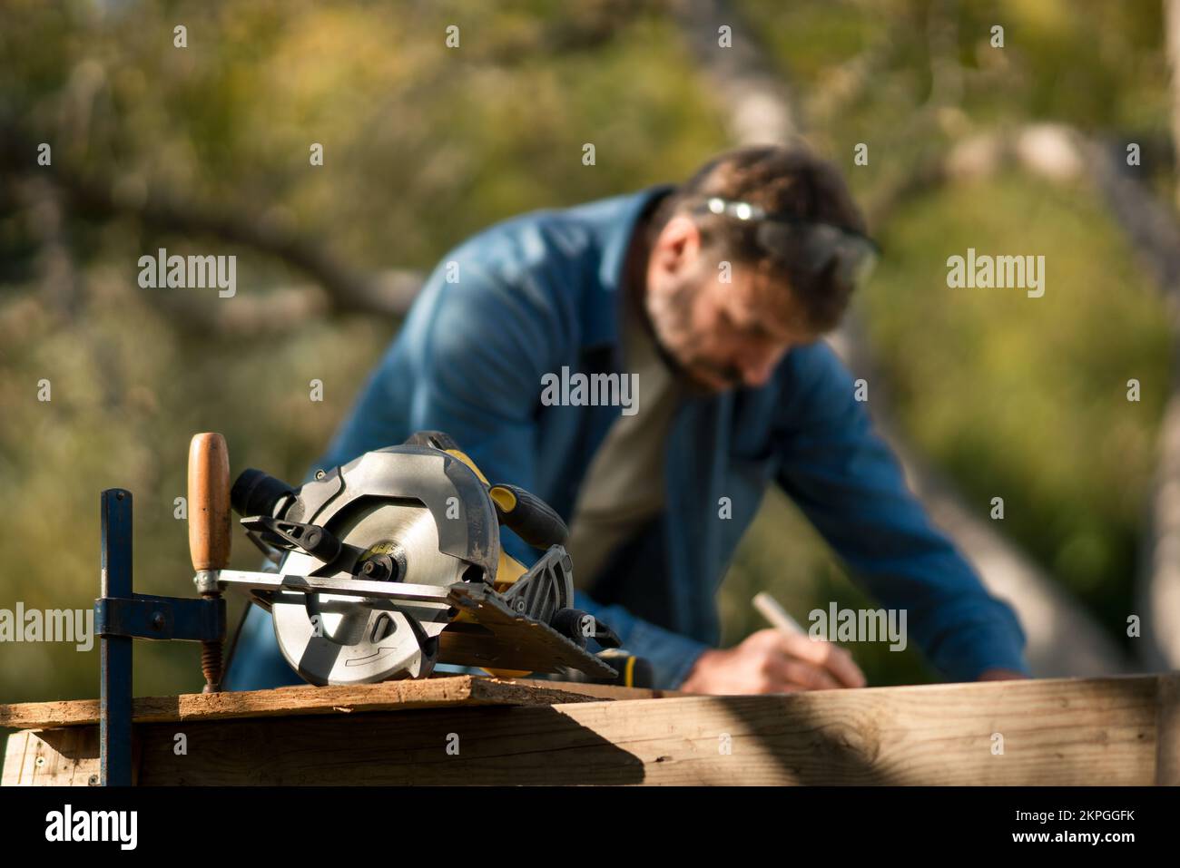 Mature handyman measuring board, outside in garden Stock Photo - Alamy