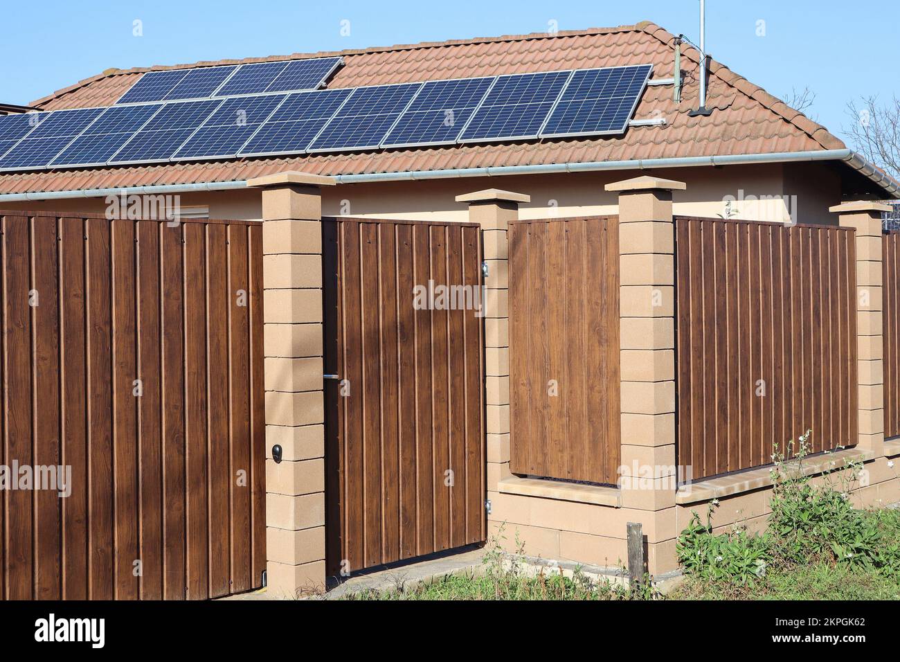 Wooden fence and solar panels on the roof Stock Photo - Alamy