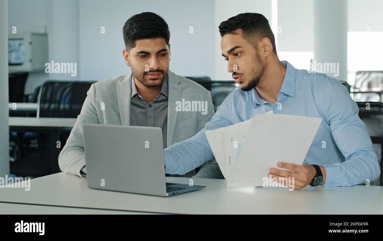Diverse male employees Arab young colleagues discussing working ... Diverse male employees Arab young colleagues discussing working ...