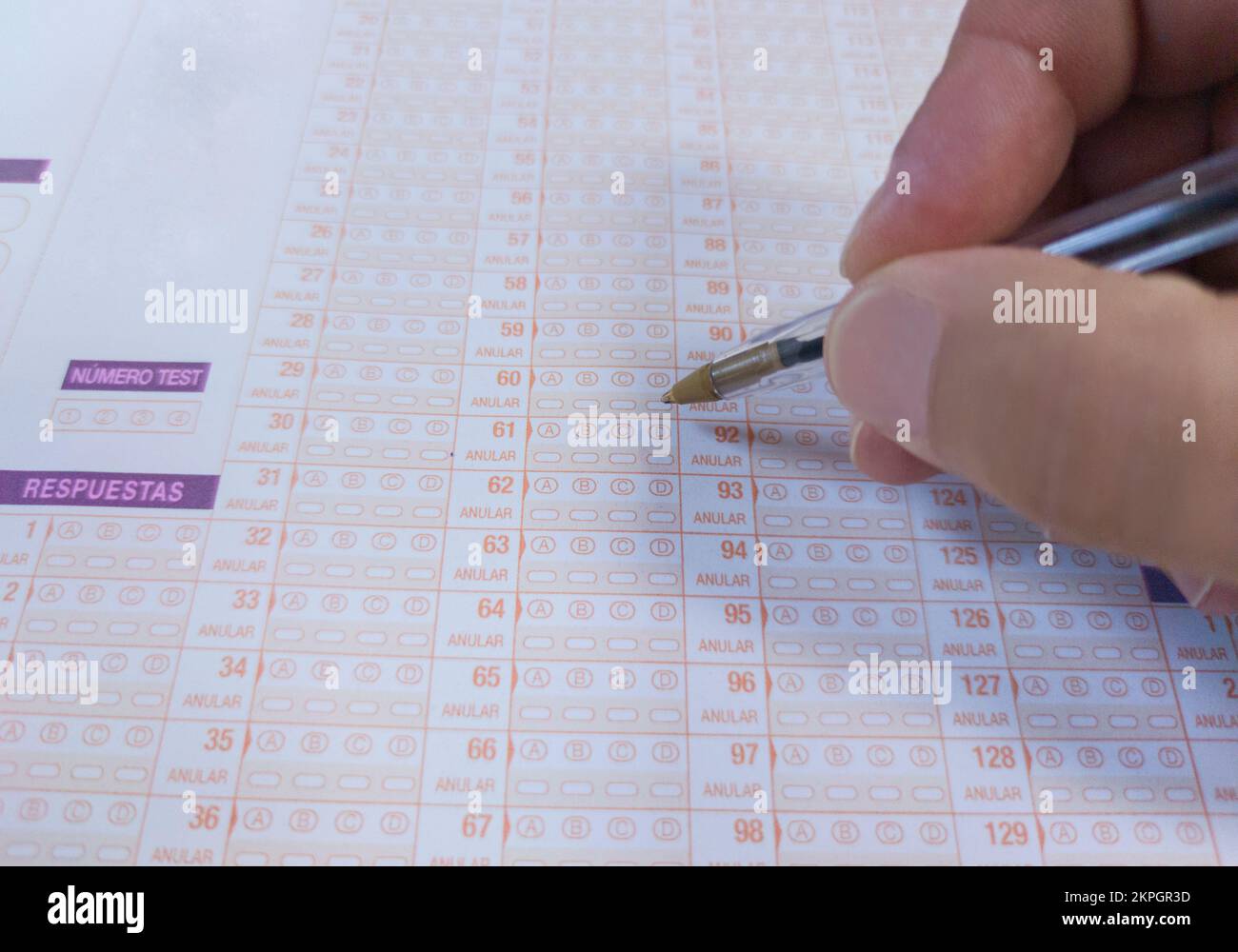 Candidate hand holds a ballpen over multiple-choice test. Public ...
