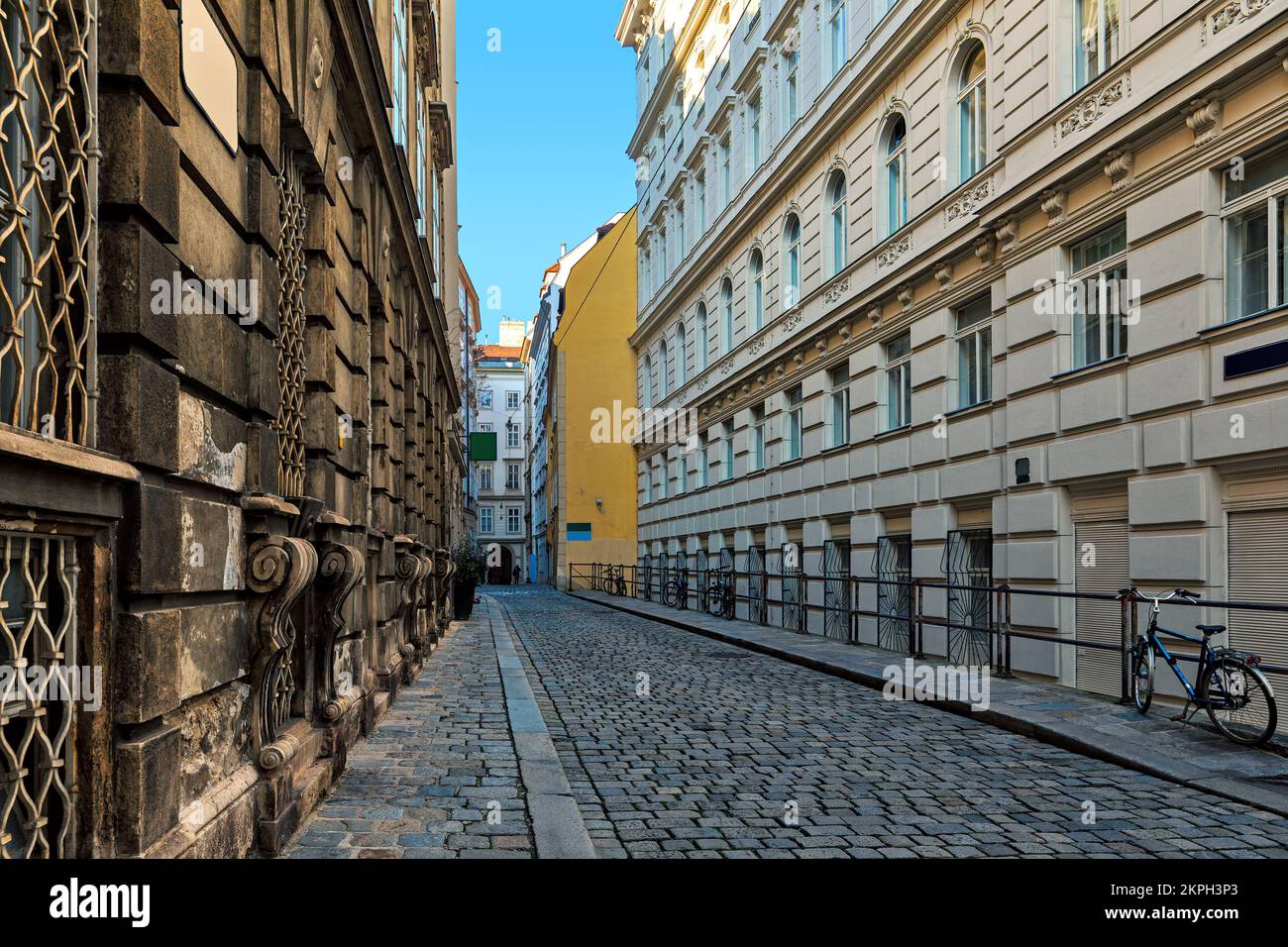 View of narrow cobblestone street among buildings in old historic part ...