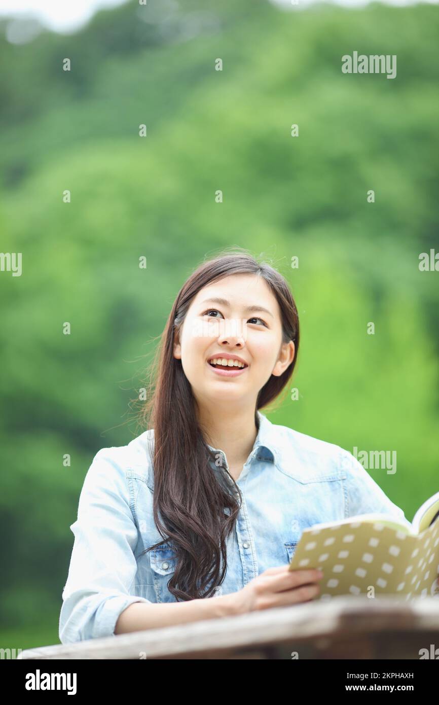 Japanese woman reading a book in the outdoors Stock Photo - Alamy