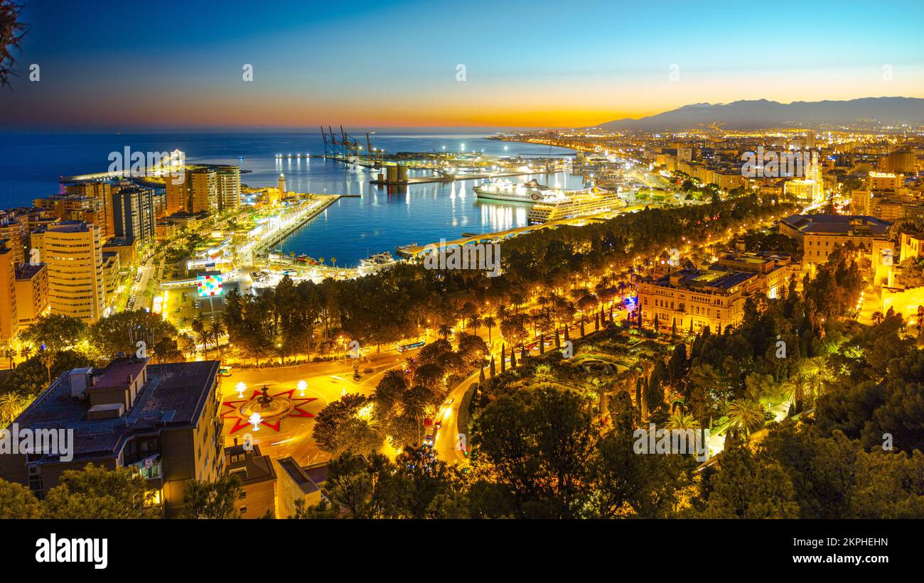 The city lights of Malaga shine bright during the blue hour Stock Photo ...