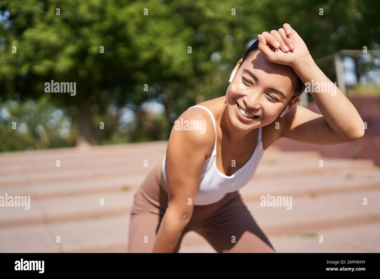 Portrait of asian woman taking break, breathing heavily and panting ...