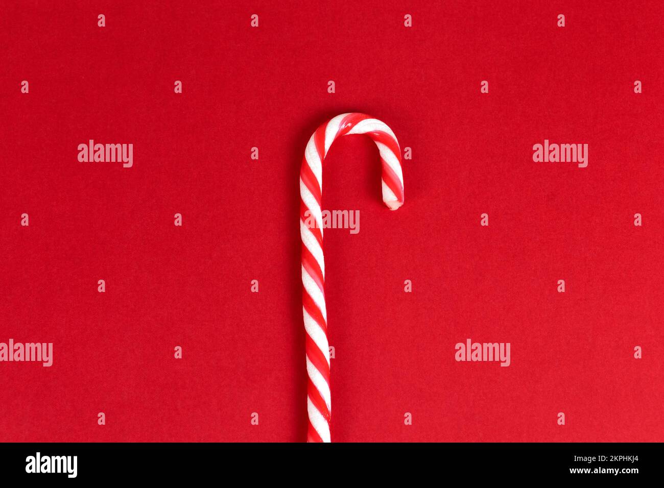 Red minimalistic christmas background with a candy cane top view with ...