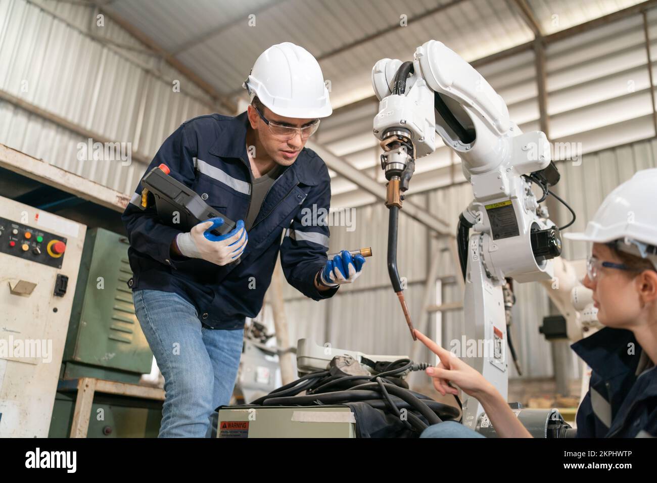Robotics engineer working on maintenance of modern robotic arm in ...