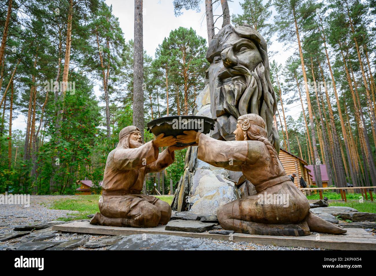 Wooden sculpture of a forest deity and people worshipping her in the ...