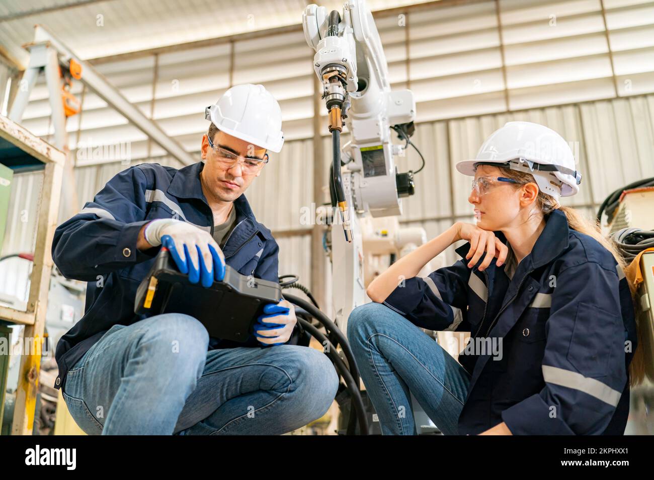 Robotics engineer working on maintenance of modern robotic arm in ...
