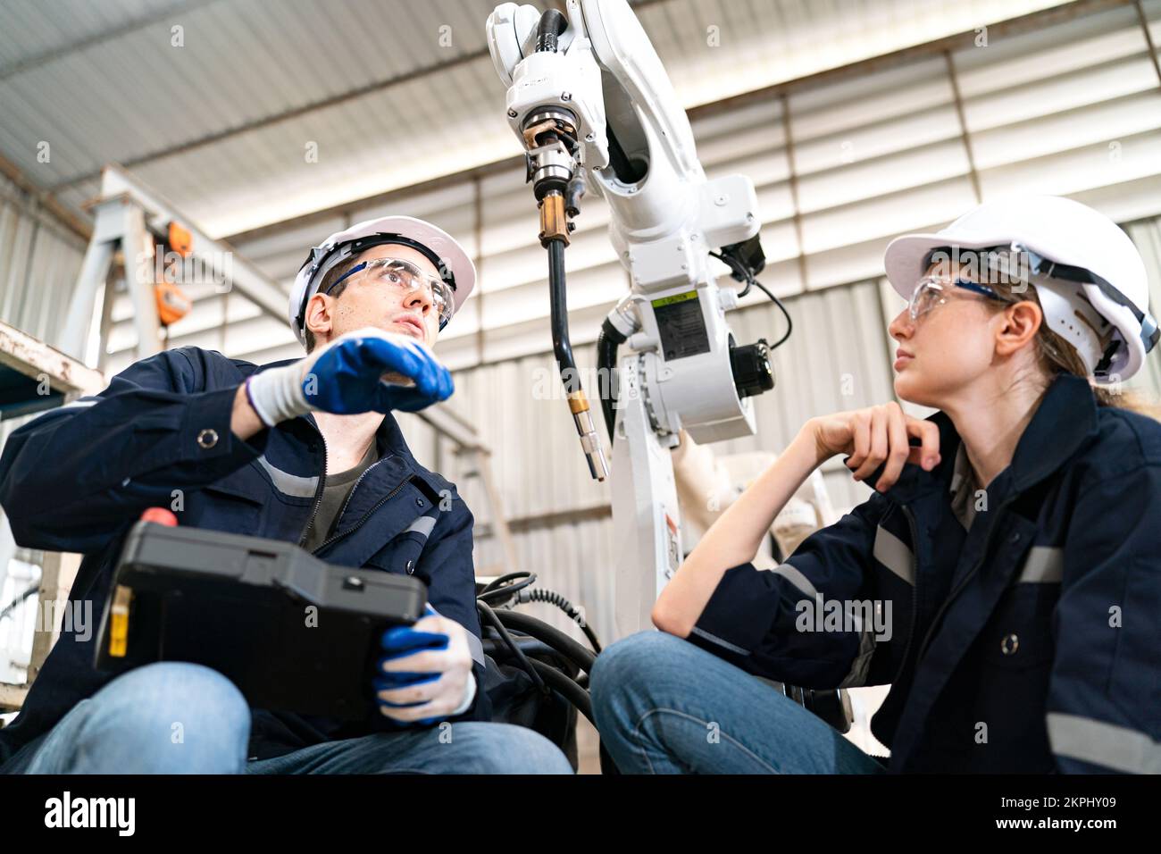 Robotics engineer working on maintenance of modern robotic arm in ...