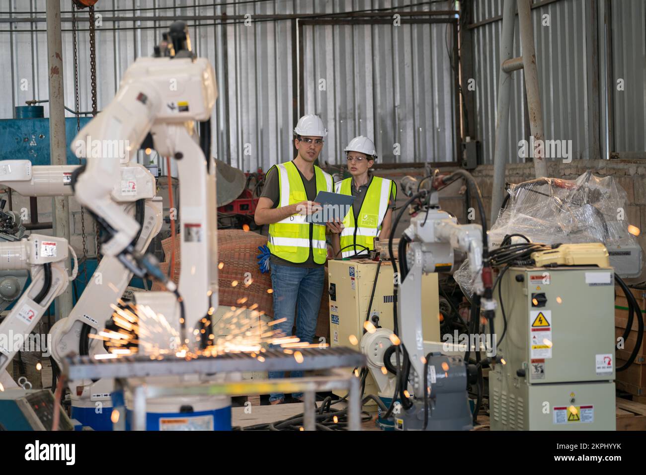 Robotics engineer working on maintenance of modern robotic arm in ...
