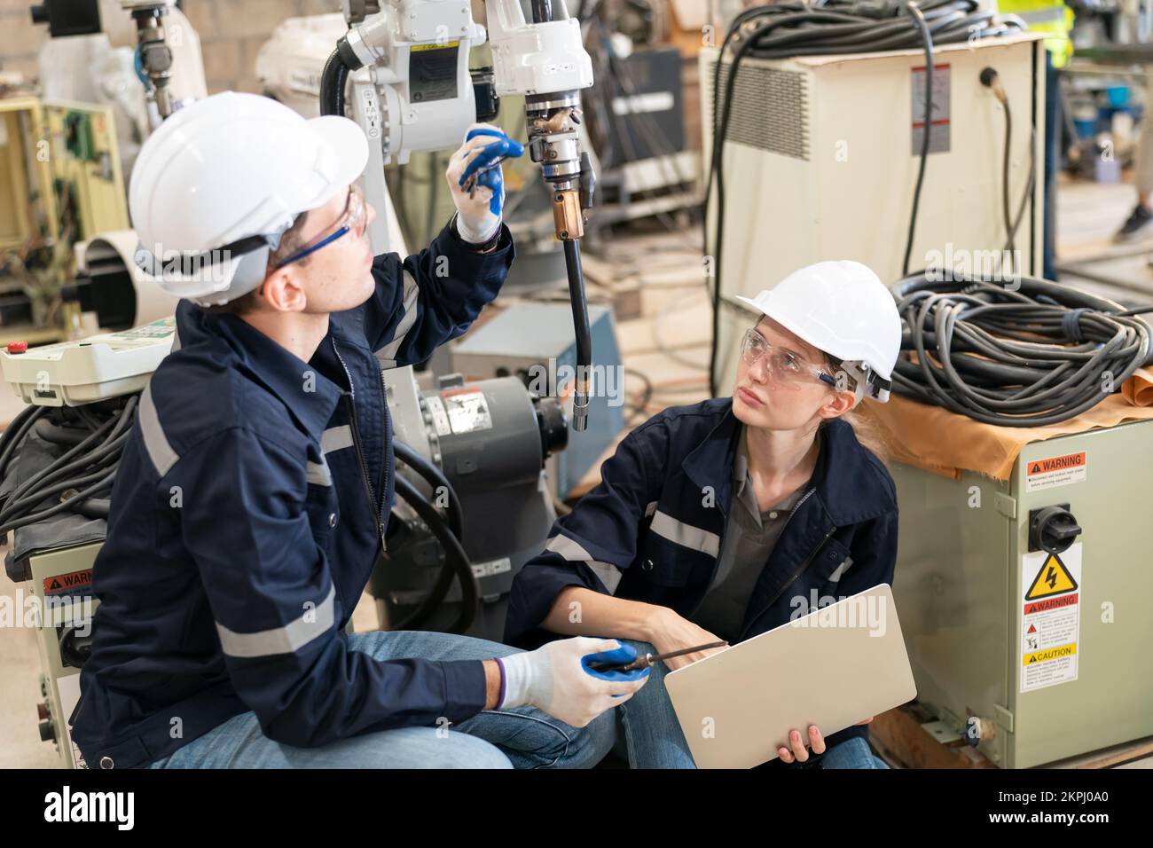 Robotics engineer working on maintenance of modern robotic arm in ...