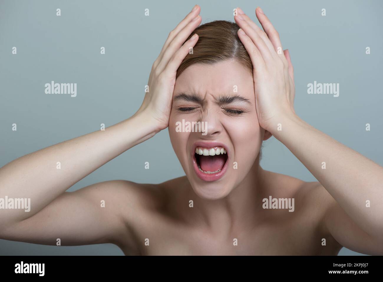 Young sad woman cryes and touches her head. Portrait of lady feeling ...