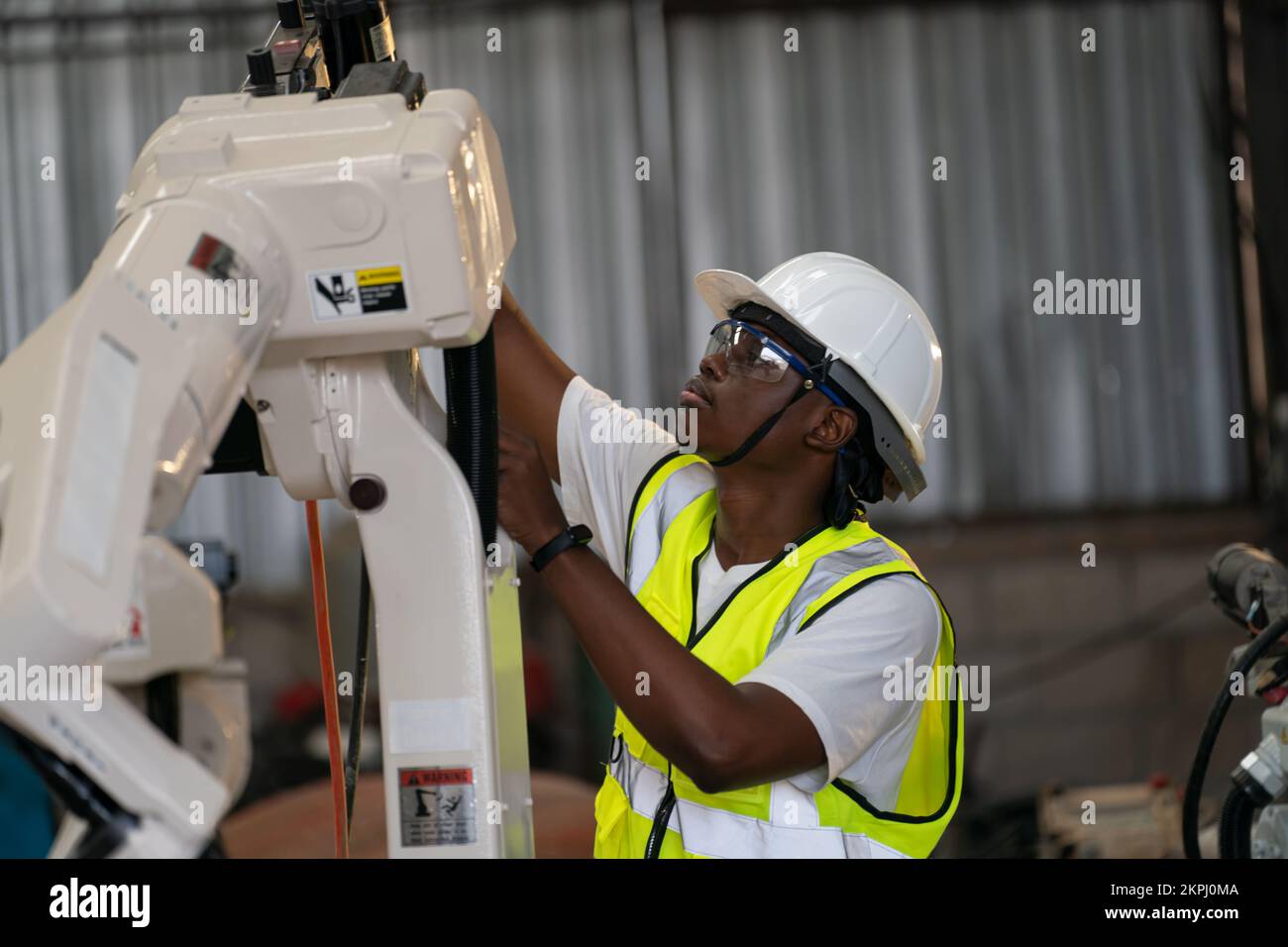 Robotics engineer working on maintenance of modern robotic arm in ...