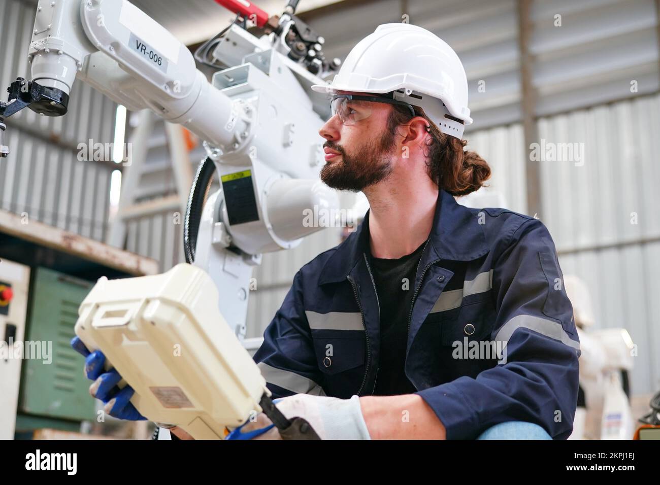Robotics engineer working on maintenance of modern robotic arm in ...