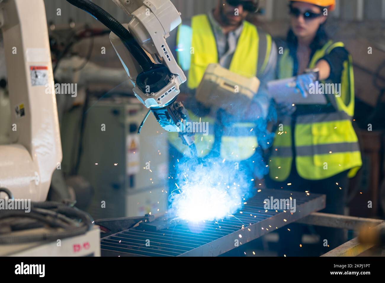 Robotics engineer working on maintenance of modern robotic arm in ...