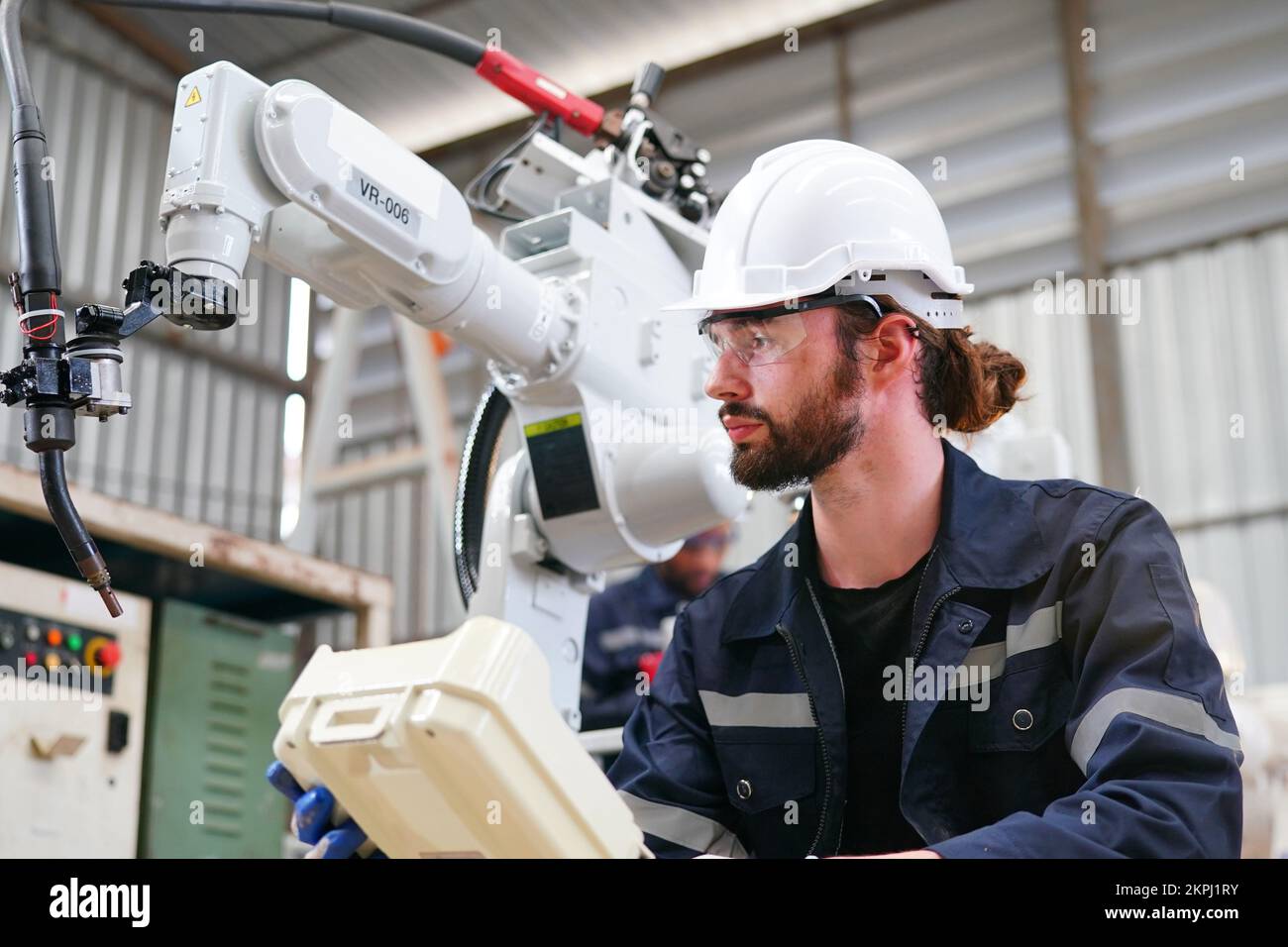 Robotics engineer working on maintenance of modern robotic arm in ...