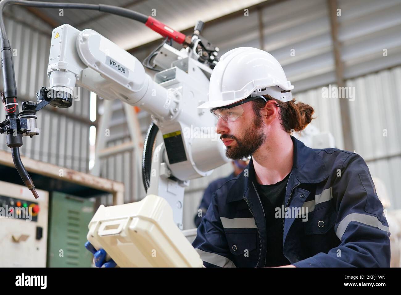Robotics engineer working on maintenance of modern robotic arm in ...