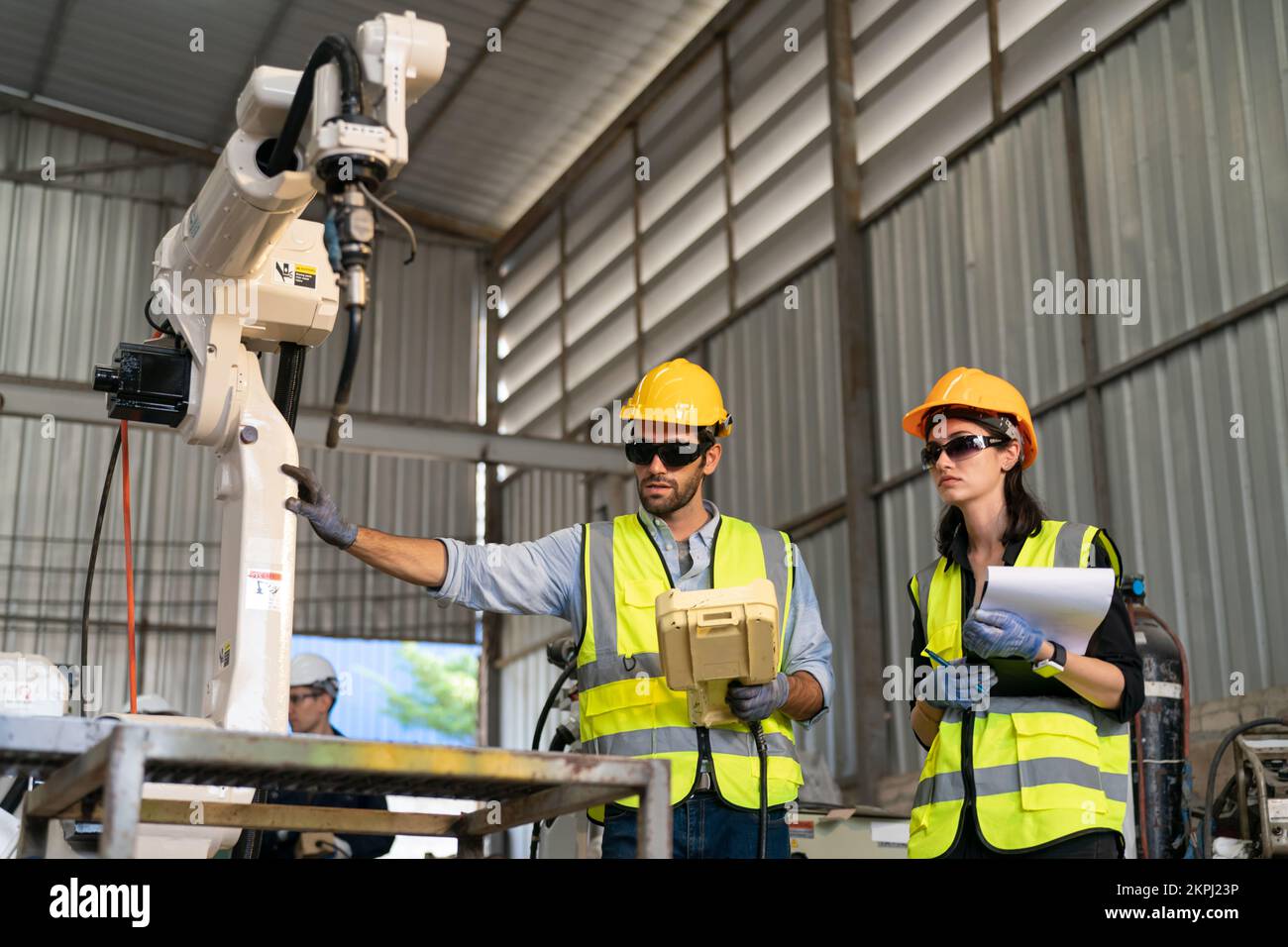 Robotics engineer working on maintenance of modern robotic arm in ...