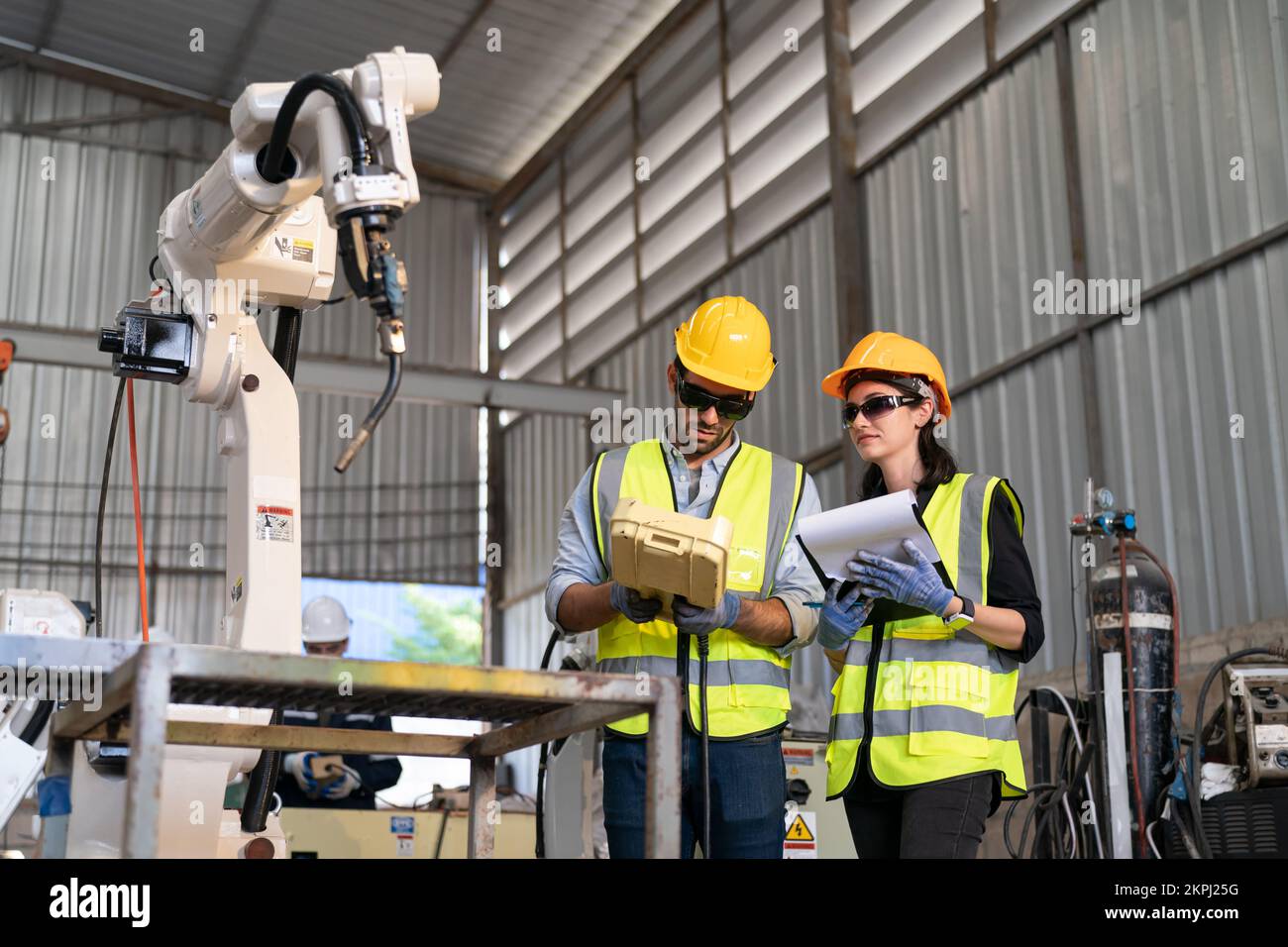 Robotics engineer working on maintenance of modern robotic arm in ...