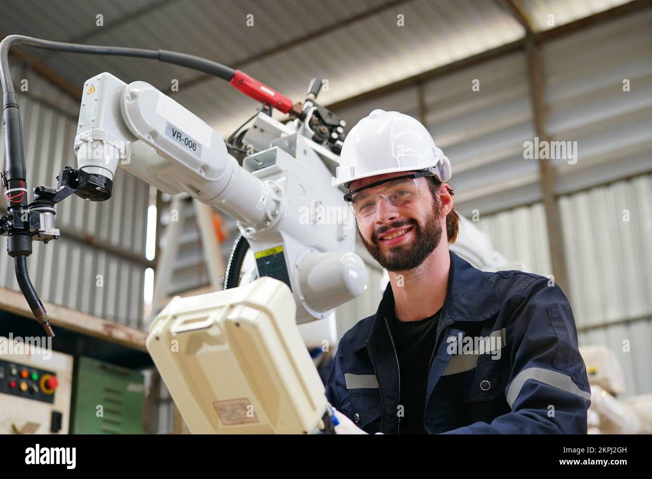 Robotics engineer working on maintenance of modern robotic arm in ...