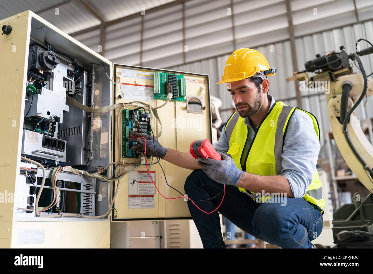 Robotics engineer working on maintenance of modern robotic arm in ...