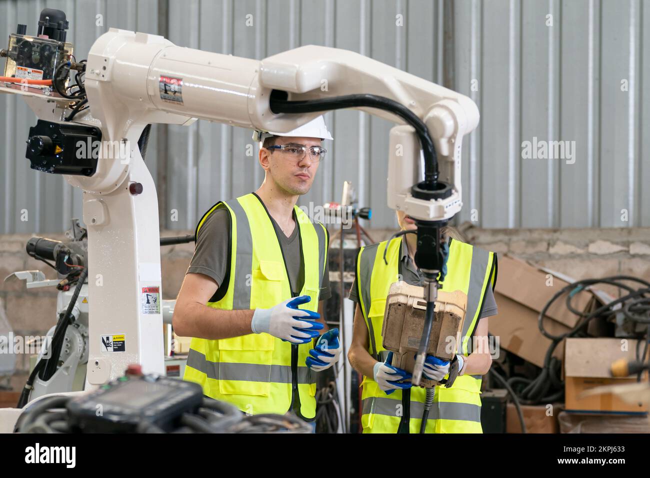 Robotics engineer working on maintenance of modern robotic arm in ...