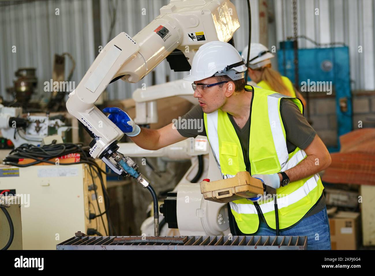Robotics engineer working on maintenance of modern robotic arm in ...