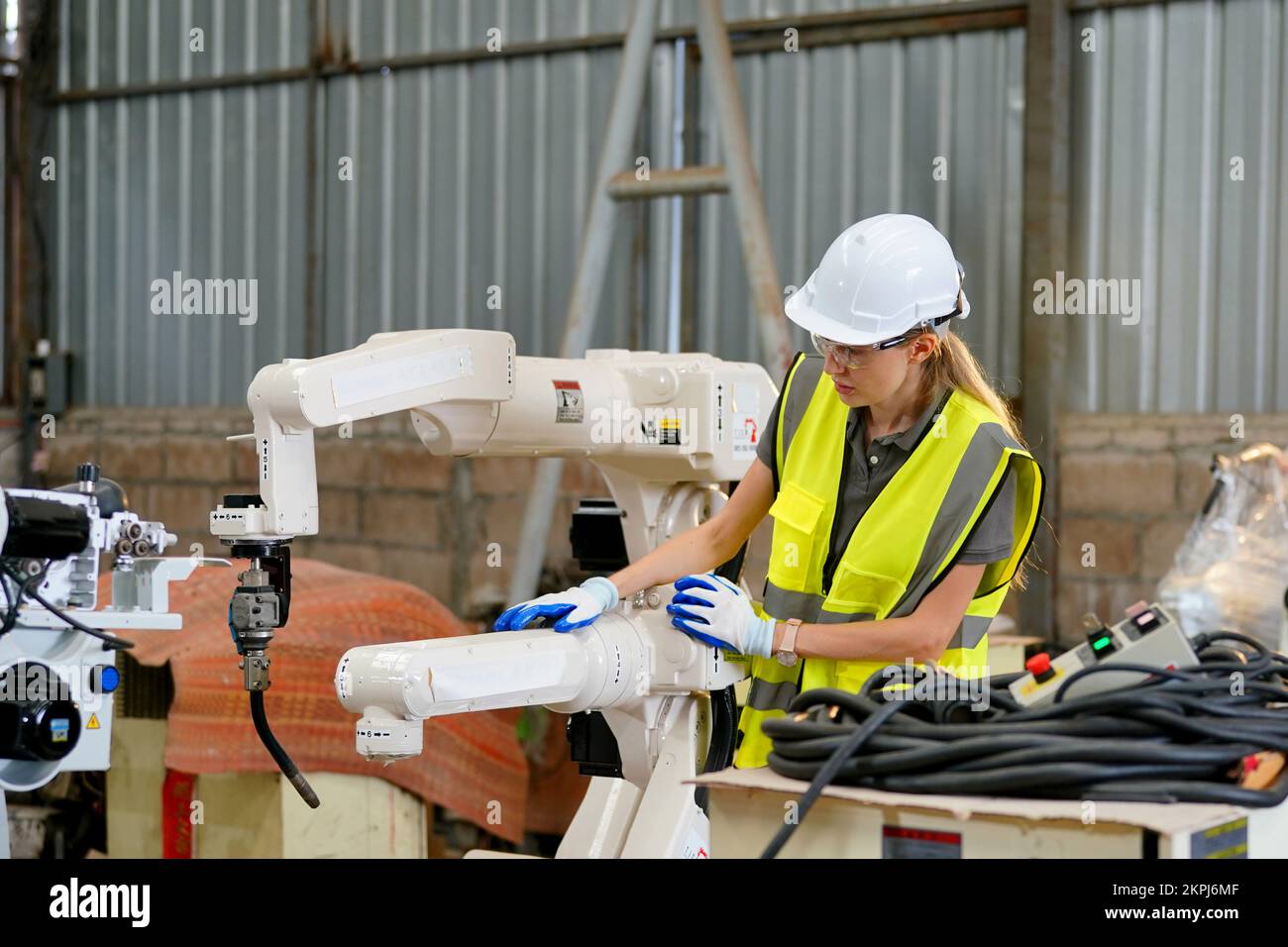 Robotics engineer working on maintenance of modern robotic arm in ...