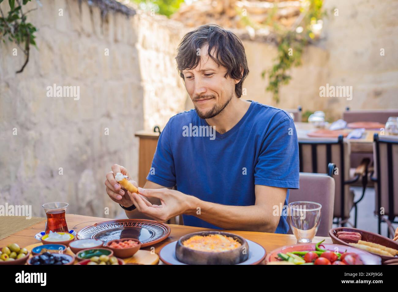 Man eating turkish breakfast. Turkish breakfast table. Pastries ...