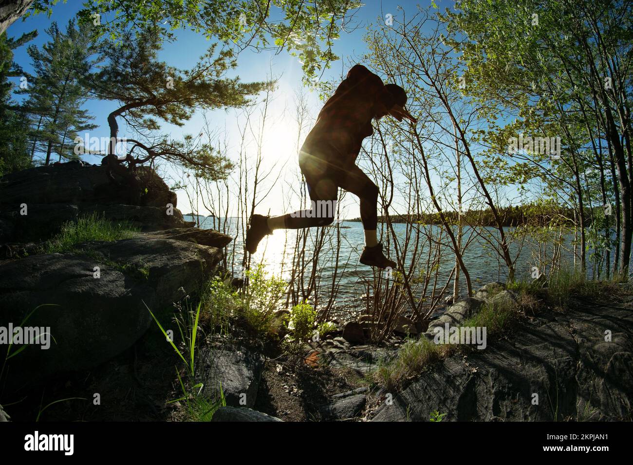 A man jumping in the lake shore Stock Photo - Alamy
