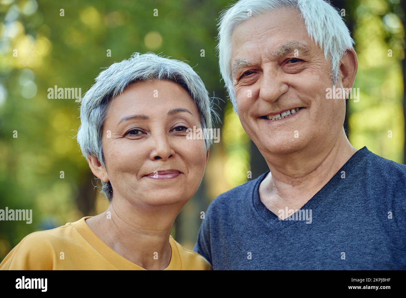 Optimistic active old 60s couple in love pose outdoor, smile looking at camera during a morning ...