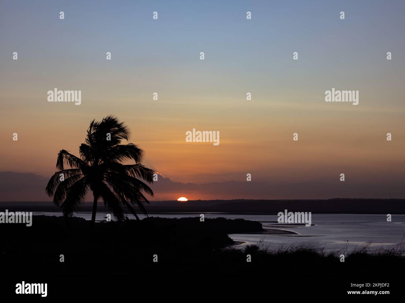 Beautiful tropical sunset in a lagoon with palm trees Stock Photo - Alamy