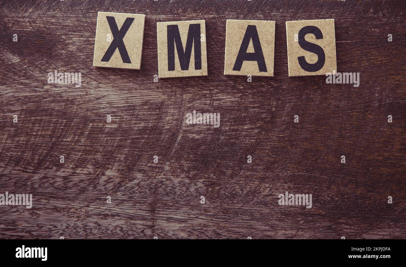 The letters of the abbreviation of the word christmas on a rustic ...