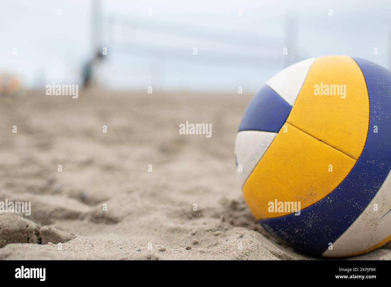 blue, white and yellow volleyball ball in the sand Stock Photo - Alamy