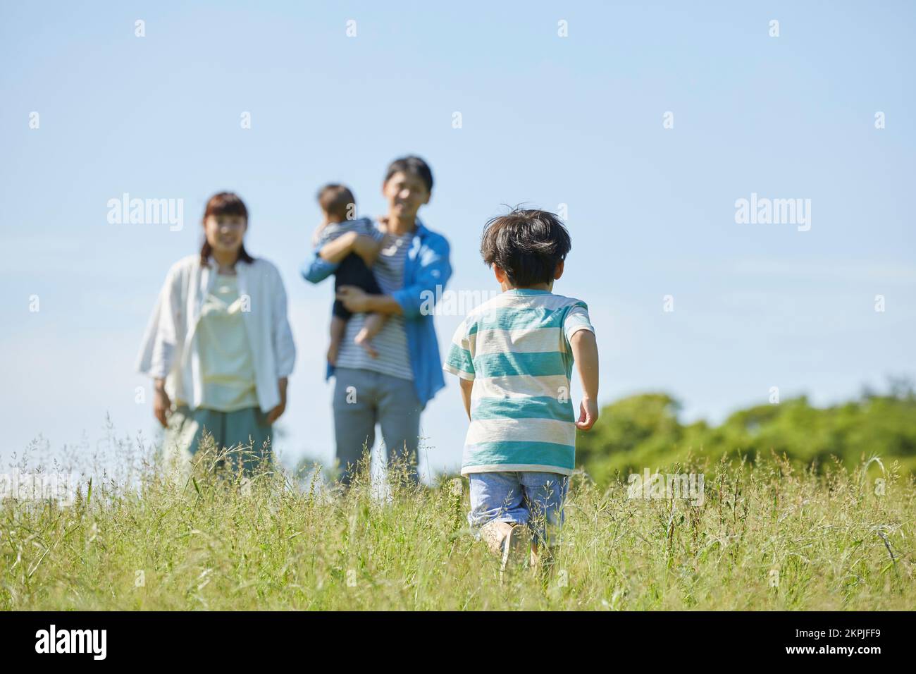 Japanese parents watching over running child Stock Photo - Alamy