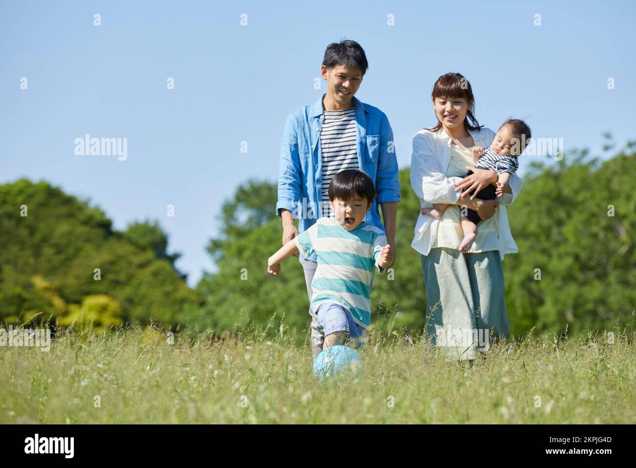 Japanese parents watching over child playing ball Stock Photo - Alamy