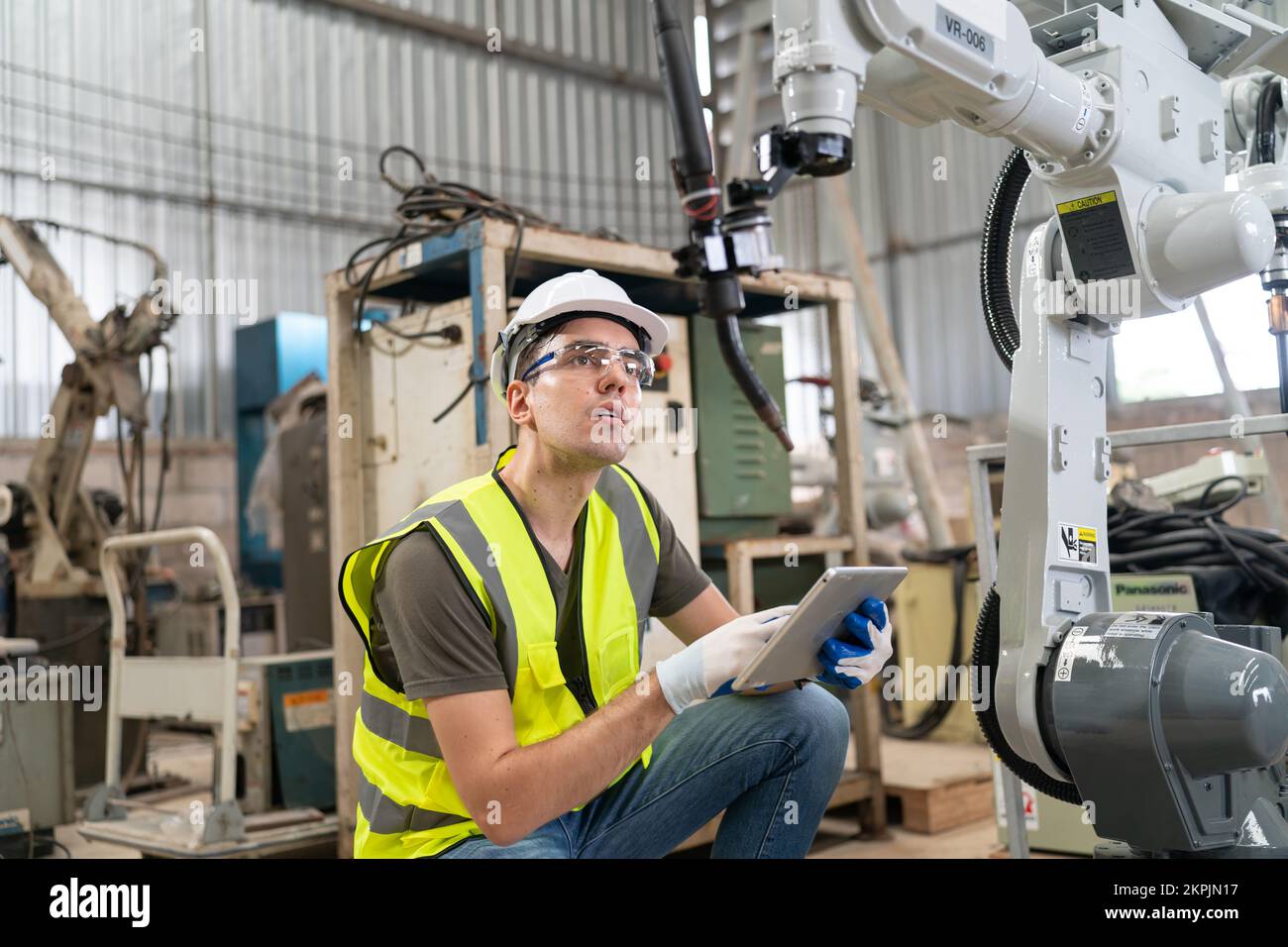Robotics engineer working on maintenance of modern robotic arm in ...