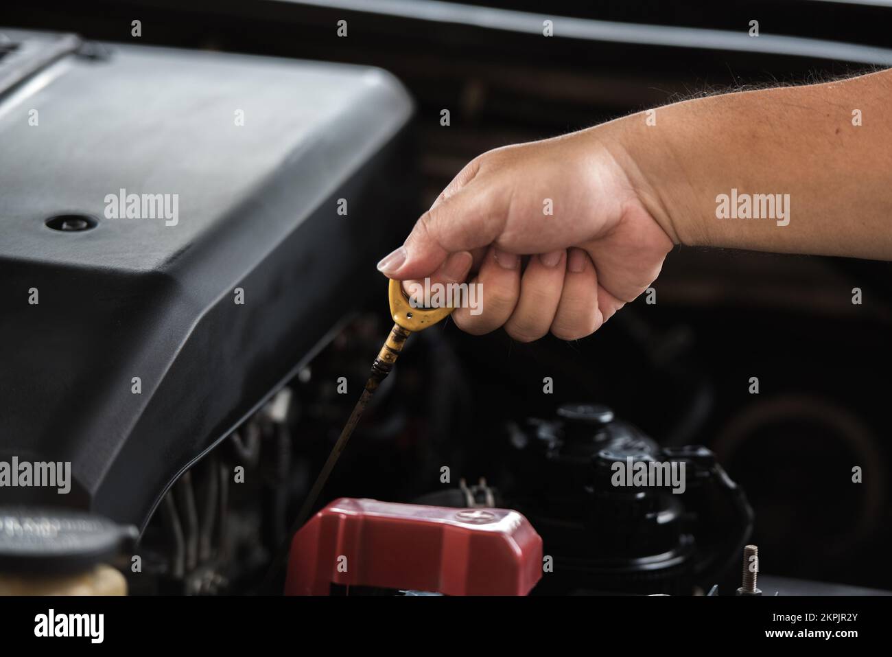 Man hand pulling oil gauge stick up for checking level of motor oil ...