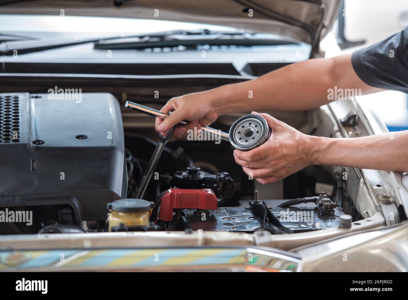 Action of man hands holding oil filter cap wrench and automotive oil ...