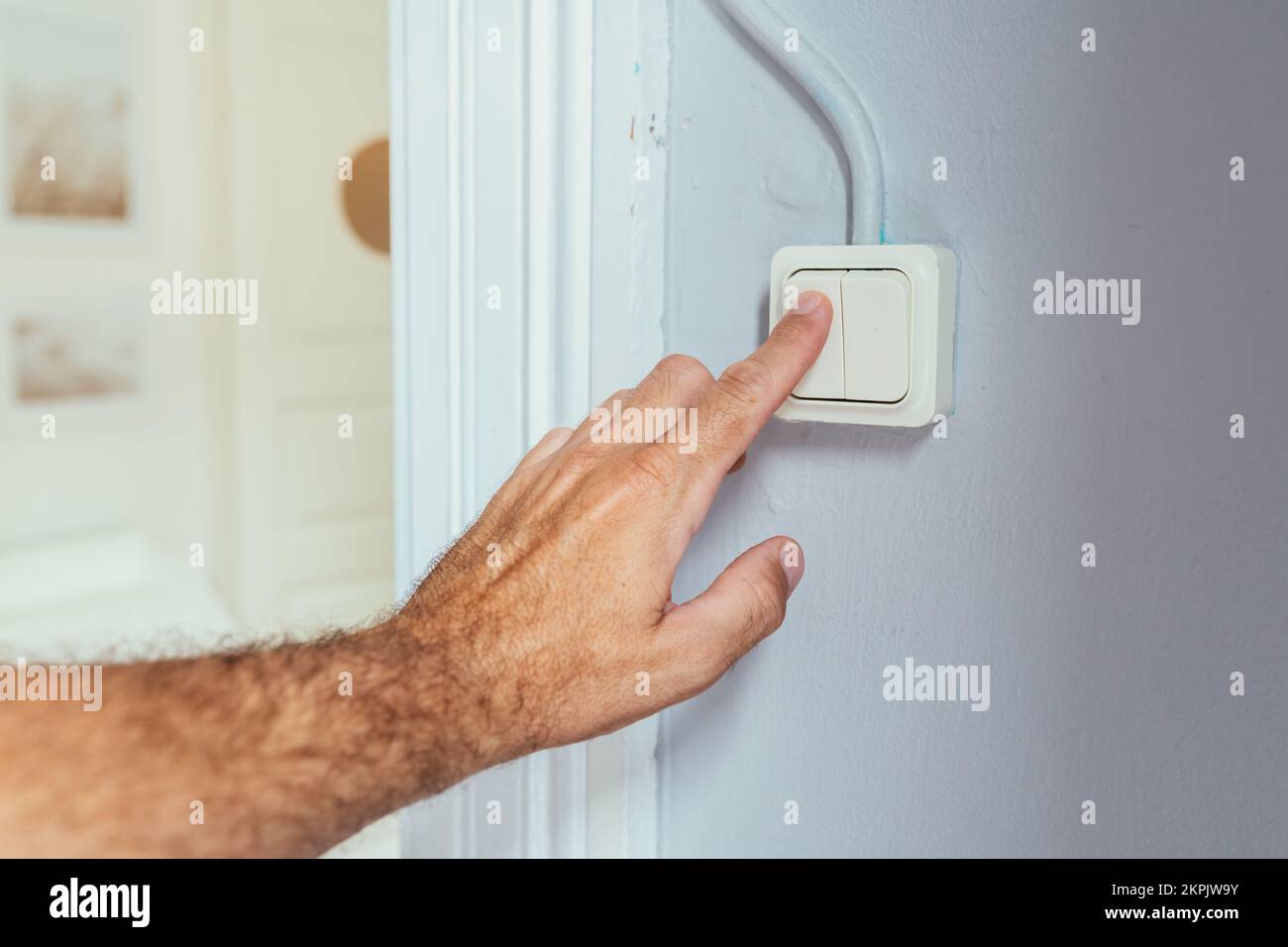 Male hand pushing old retro light switch in living room, selective ...