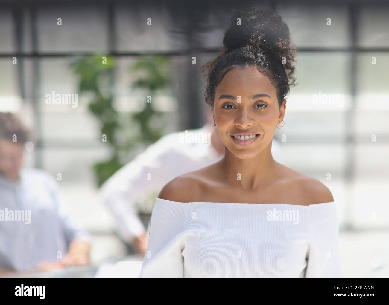 a business woman smiling inside office building Stock Photo - Alamy